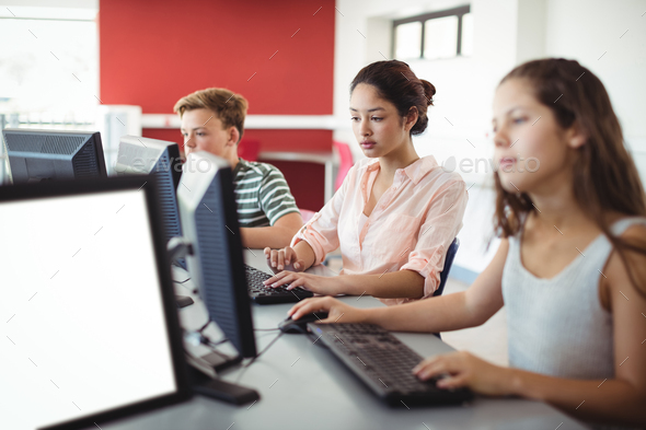 Students using computer in classroom Stock Photo by Wavebreakmedia