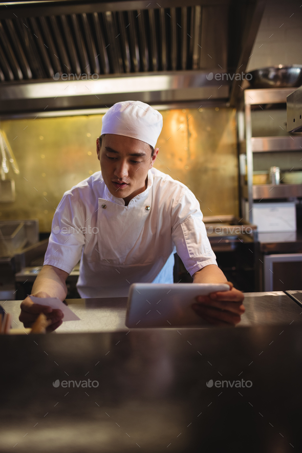 Chef looking at an order list in the commercial kitchen Stock Photo by ...