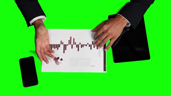 Overhead view of a Caucasian man explaining graphs with green screen ...