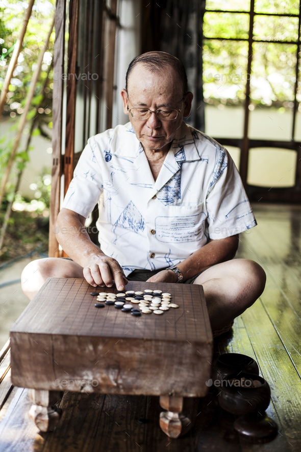 Japanese man sitting on floor on porch of traditional Japanese house ...