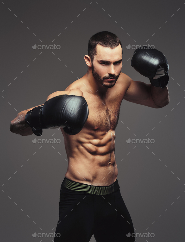 Studio portrait of a shirtless brutal athletic boxer wearing black ...