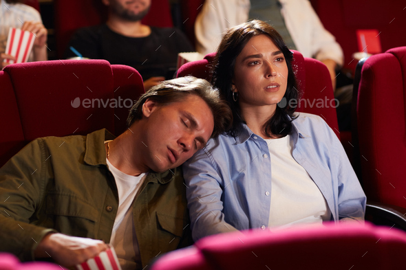 Bored Man Falling Asleep in Cinema Stock Photo by seventyfourimages