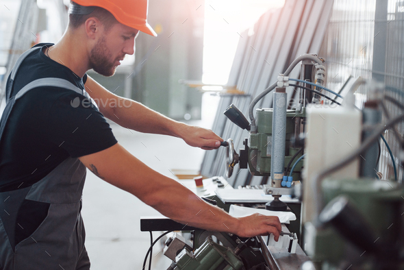 Operator of machine. Industrial worker indoors in factory. Young ...