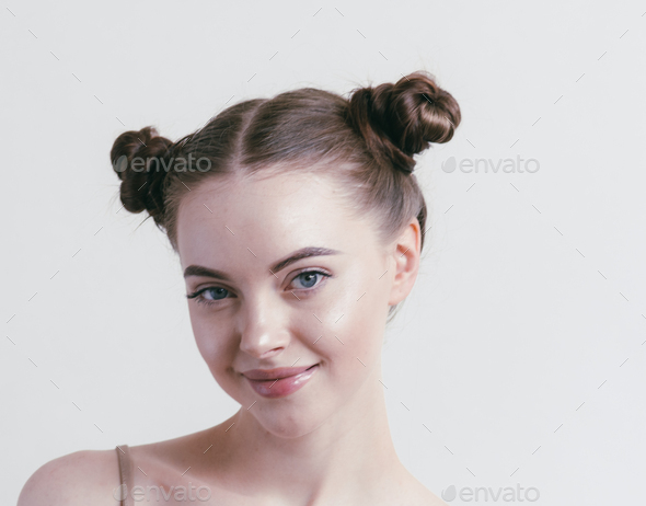 Portrait of brunette woman with bun of dark hair. Stock Photo by kiraliffe