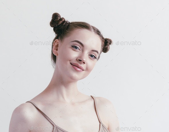 Portrait of brunette woman with bun of dark hair. Stock Photo by kiraliffe