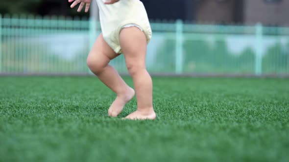 Toddler Legs Learning to Walk with Bare Feet on Green Grass, Stock Footage