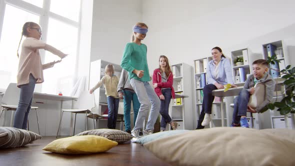 Blindfolded Teenager Carefully Edging around Cushions with Directions ...