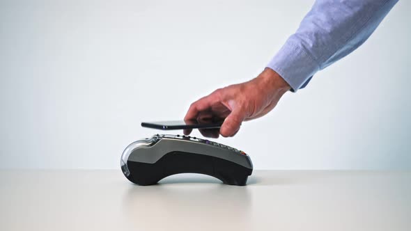 Mobile NFC Payment. Hand of Customer Paying with Mobile Phone Over Pos ...