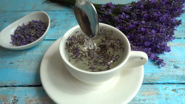 Tea from fresh lavender flowers on a vintage wooden background. Tea is ...