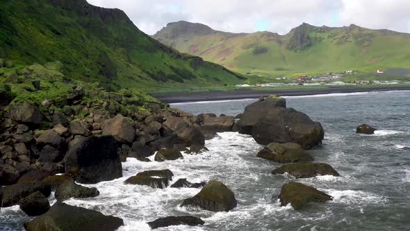 Vik, Iceland coast with waves crashing on rocks with drone video moving ...