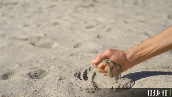 Gently picking up a handful of sand and pouring out close-up, Stock Footage