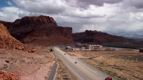 Entering Moab Utah along Highway 191 on a cloudy day, aerial, Stock Footage