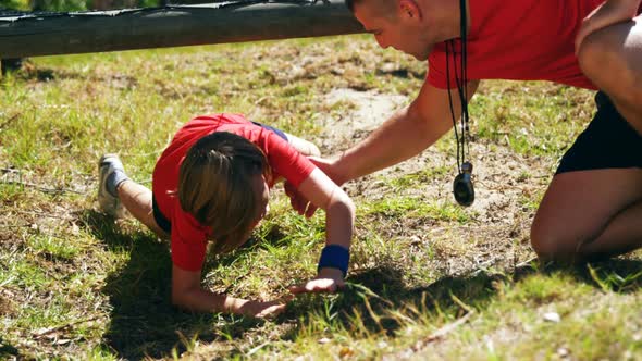 Kids crawling under the net during obstacle course training, Stock Footage