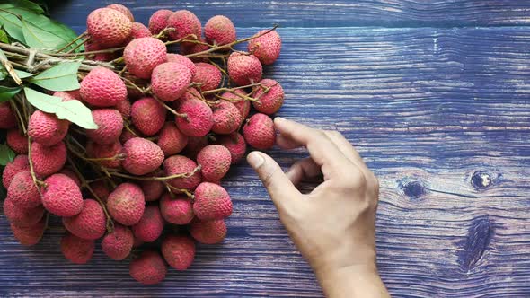 Hand Pick Lychee on a Wooden Background Top Down, Stock Footage | VideoHive