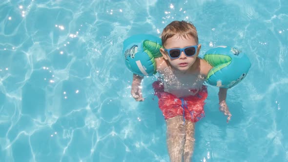 Cute Caucasian boy Relaxing on Swimming pool wearing sunglasses and ...