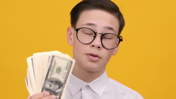 Rich Teenager Boy Holding Money Over Yellow Background, Stock Footage