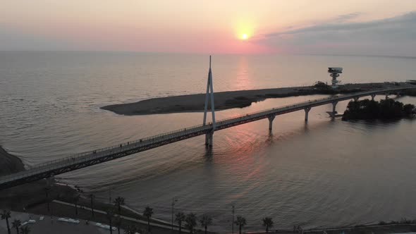 Aerial view of Anaklia-Ganmuhkuri Pedestrian Bridge at colourful sunset ...