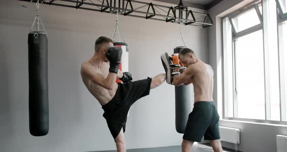 The Kickboxer is Practising His Middle Kick with Trainer in Slow Motion ...