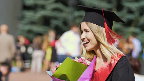 Happy Beautiful Graduating Student Holding Bunch of Flowers, Smiling to ...