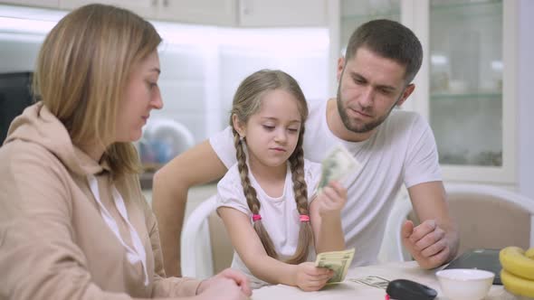 Concentrated Little Girl Counting Dollars Sharing Money with Father and ...