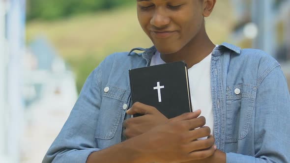 Teen African-American Boy Embracing Bible, Stock Footage | VideoHive