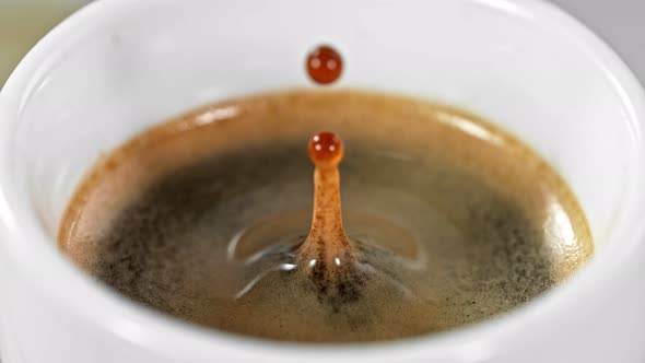 Super Slow Motion Detail Shot of Coffe Drop Falling Into Fresh Espresso ...