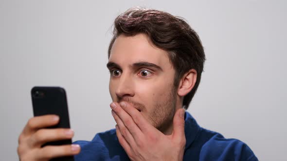 Shocked Man Reading News on Smartphone in Studio. Guy Using Mobile ...