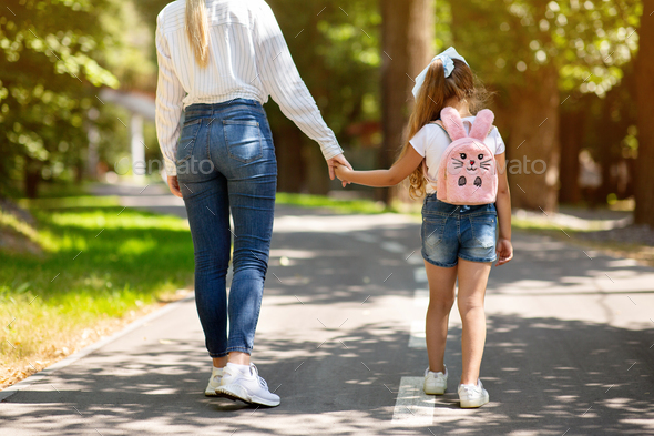 Mother And Daughter Walking Holding Hands In Park, Cropped, Back-View Stock Photo by Prostock-studio