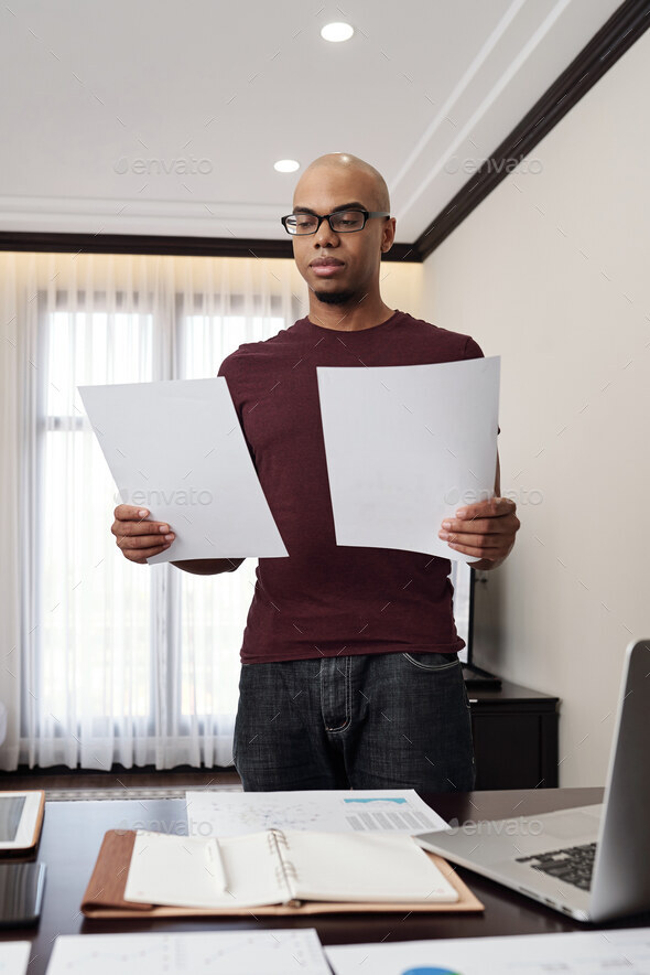 Comparing financial reports Stock Photo by DragonImages | PhotoDune