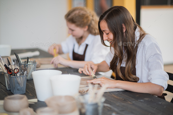 Beautiful young female artist girls creating handmade pottery in modern ...