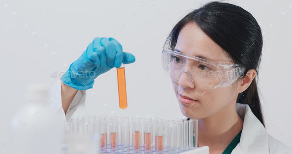 Scientist making observation on test tube Stock Photo by leungchopan