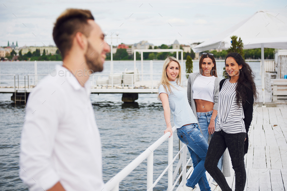 Portrait of a young and happy people at rest on the pier. Friends ...