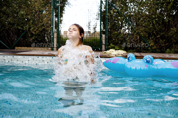 Girl swimming with raft in pool Stock Photo by astrakanimages | PhotoDune