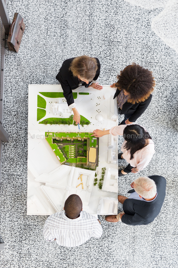 Overhead view of architects discussing blueprint Stock Photo by ...