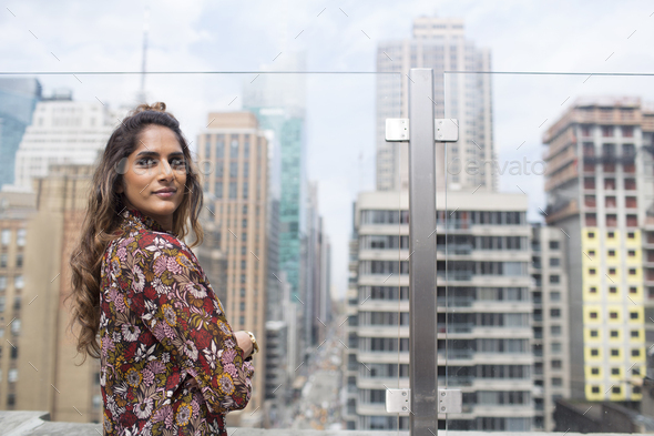 Smiling woman standing against glass window at rooftop restaurant Stock ...
