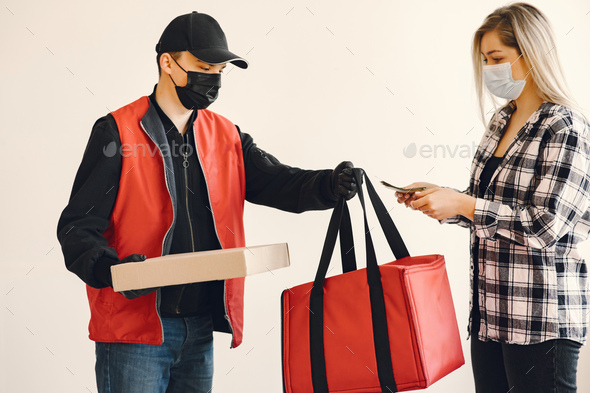 Delivery man in a medic mask with woman Stock Photo by prostooleh ...