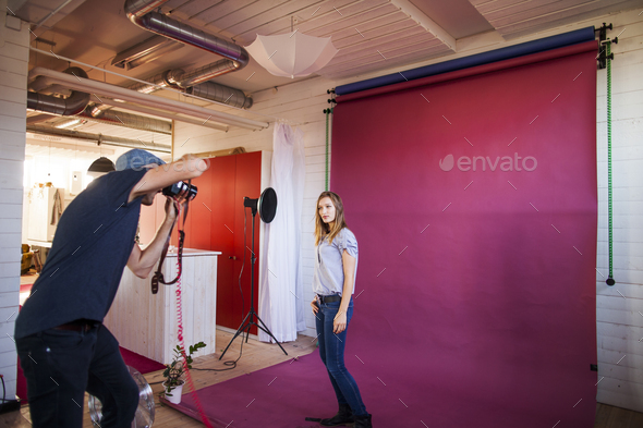 Side view of photographer photographing fashion model in studio Stock ...