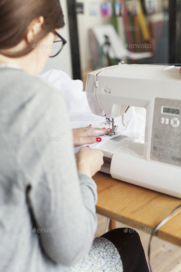 Rear view of design professional using sewing machine Stock Photo by ...