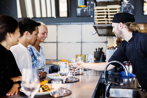 Side view of chef serving meal to customers at Sky bar restaurant Stock ...