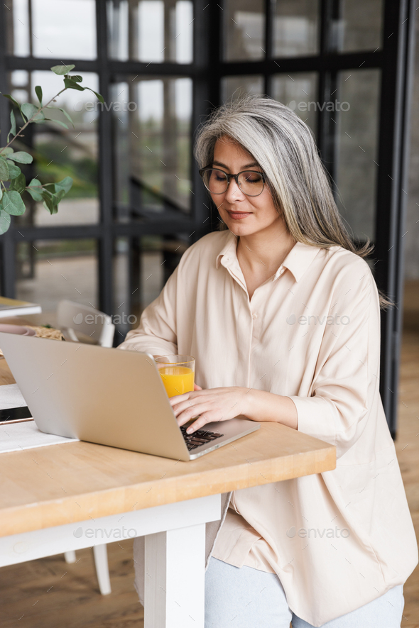 Concentrated business woman indoors using laptop computer Stock Photo ...