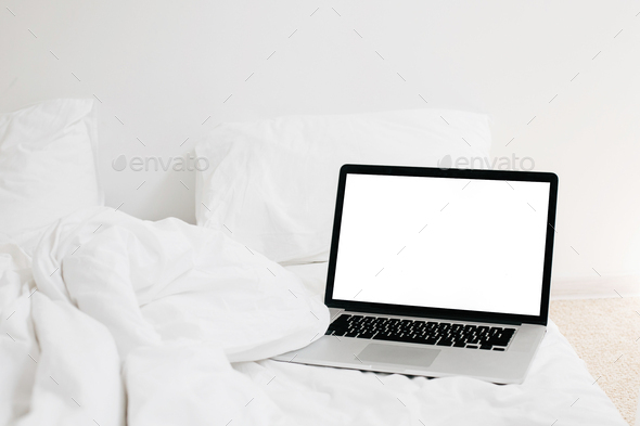 Laptop with blank white screen on white cozy bed in sunny light Stock ...