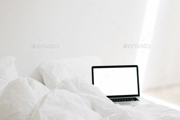 Laptop with blank white screen on white cozy bed in sunny light Stock ...