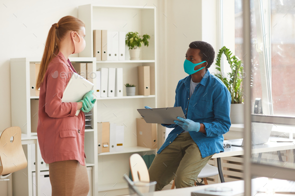 Two Young Workers Wearing PPE in Office Stock Photo by seventyfourimages