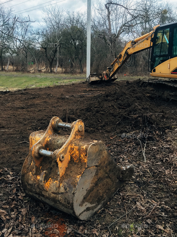 Bulldozer clearing land from old trees, roots and branches with dirt ...
