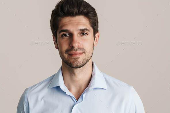 Image of happy brunette man looking at you isolated by beige background ...