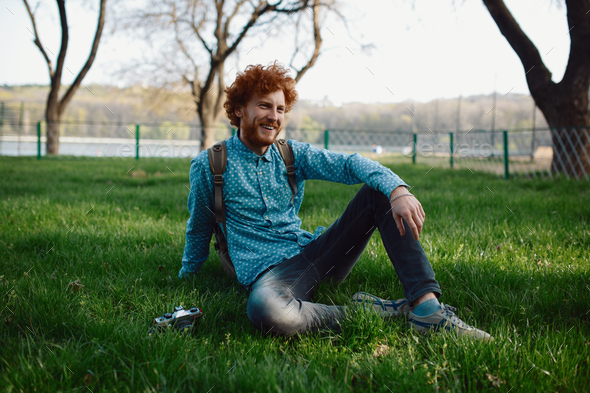 Portrait of a young happy ginger man relaxing on the grass Stock Photo ...