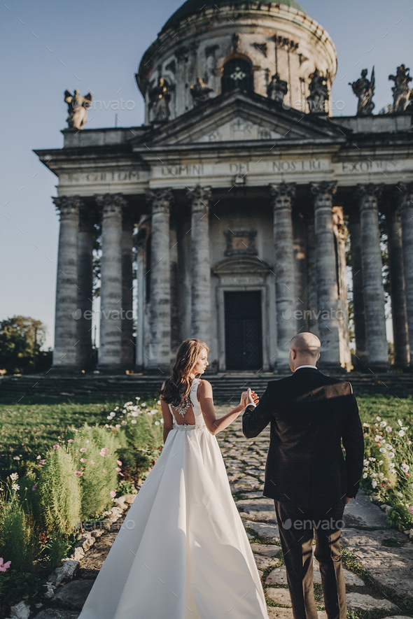 Bride and groom posing on background of ancient columns and nature ...