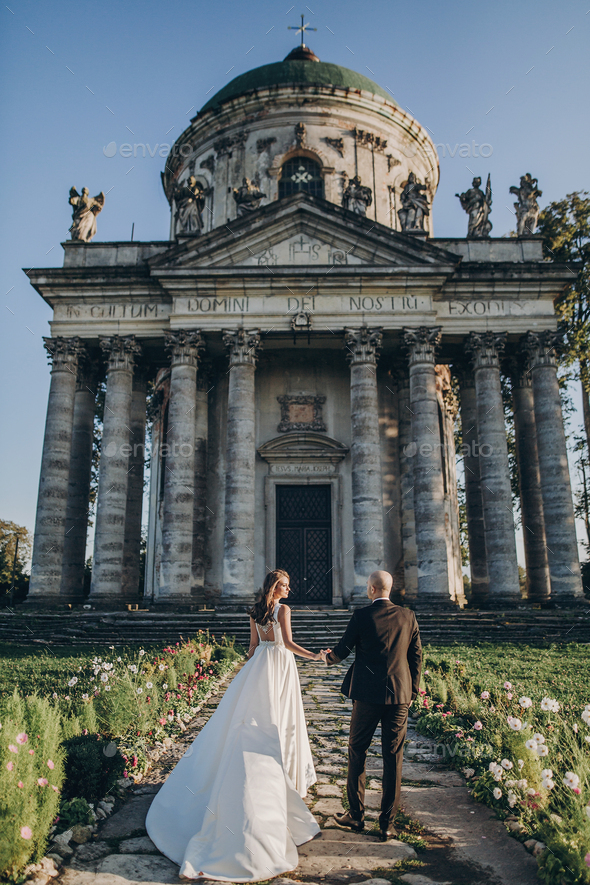 Bride and groom posing on background of ancient columns and nature ...
