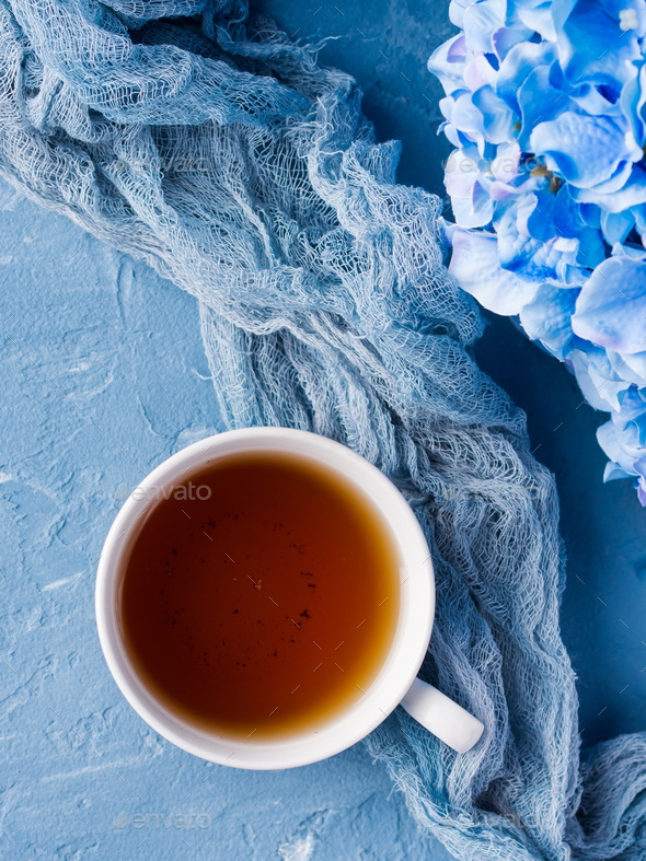 Cup of tea on blue background with flowers Stock Photo by tenkende