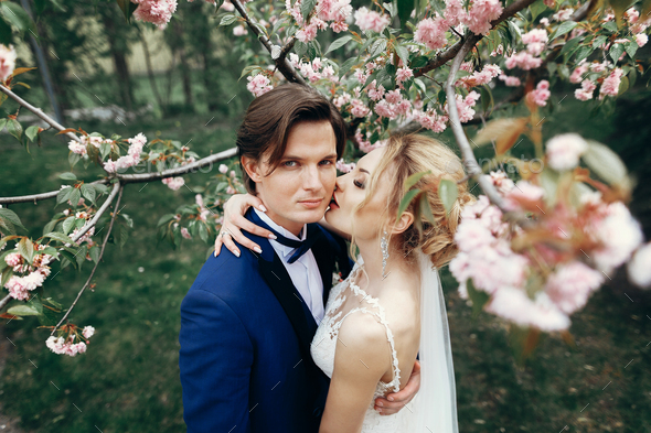 Handsome groom touching and embracing beautiful blonde bride Stock ...
